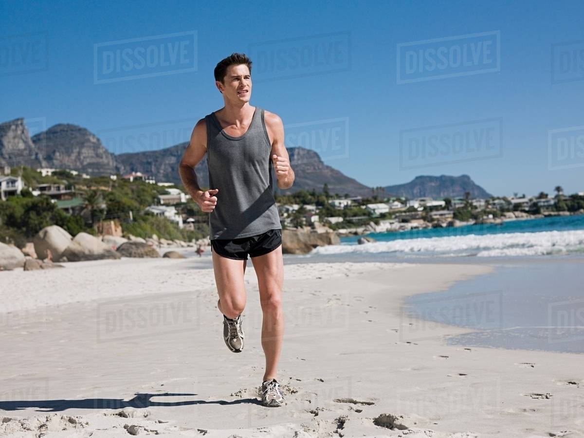 Young man jogging on beach - Royalty-free Stock Photo | Dissolve