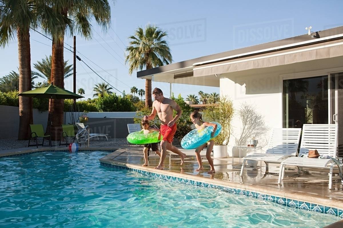 Family and outdoor swimming pool - Stock Photo - Dissolve