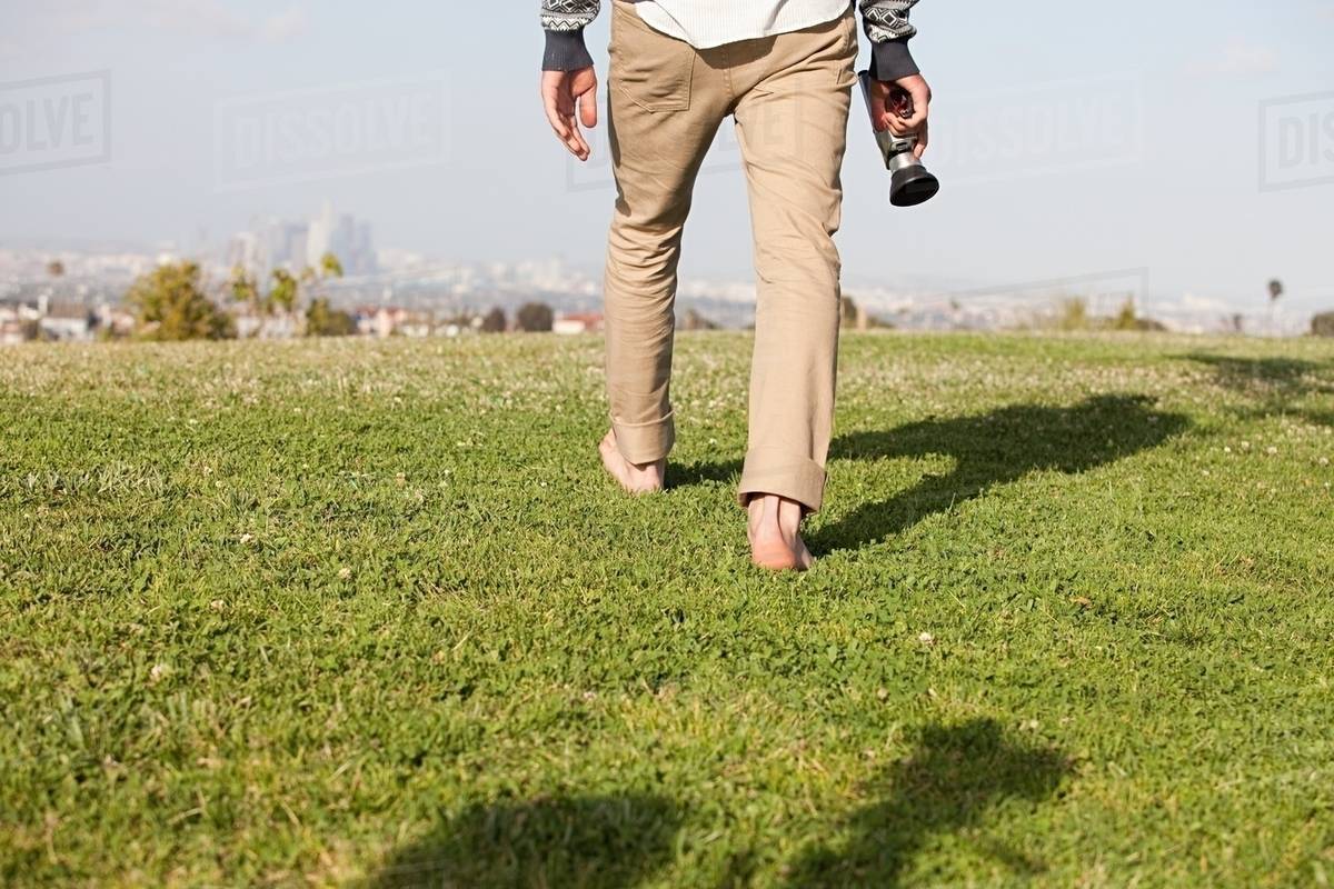 Man walking in field with video camera - Royalty-free Stock Photo ...
