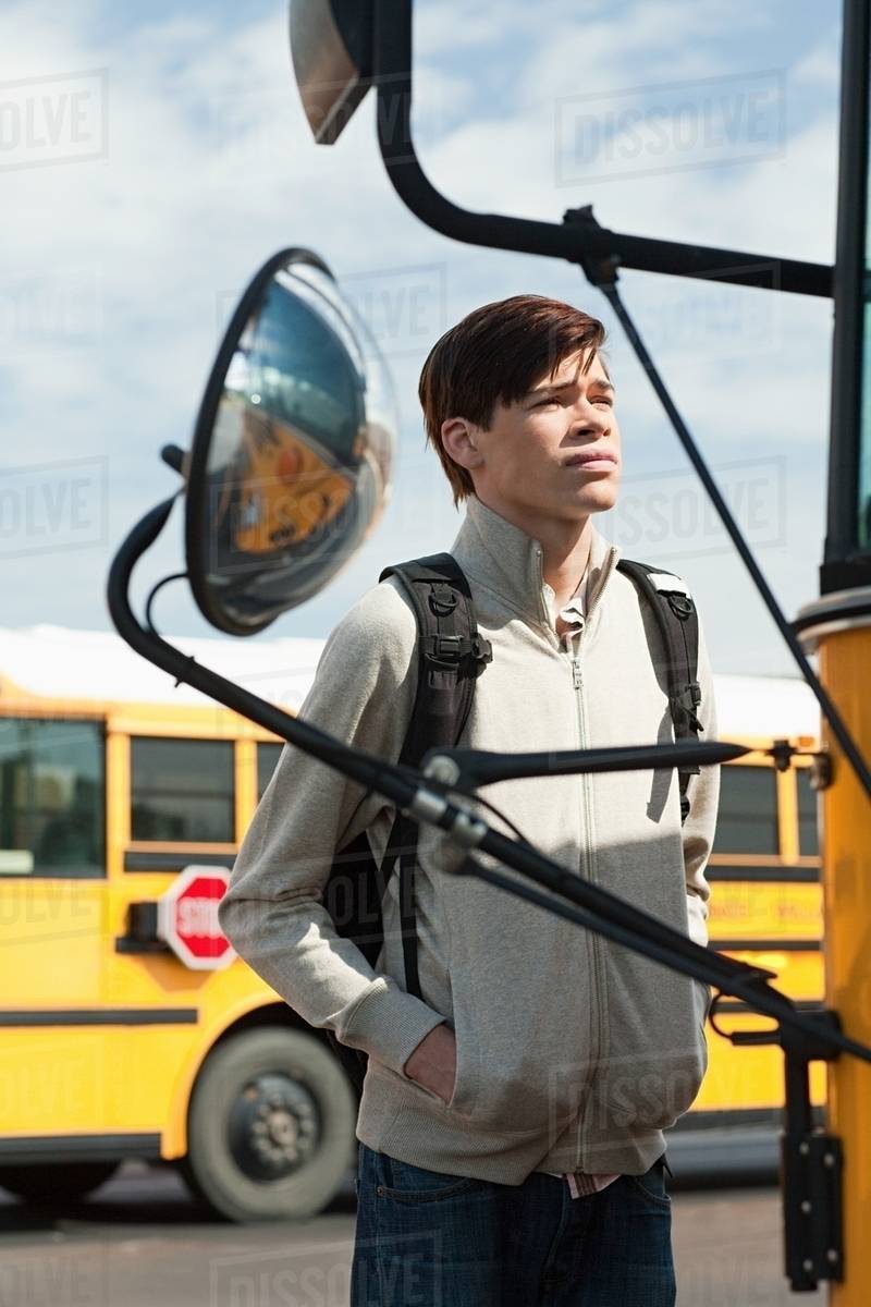 Male high school student standing outside school bus - Royalty-free ...