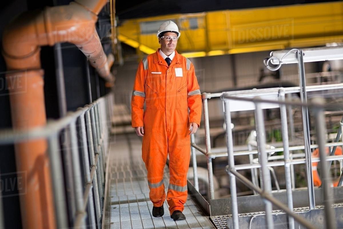 Engineer walking along walkway in factory - Royalty-free Stock Photo ...