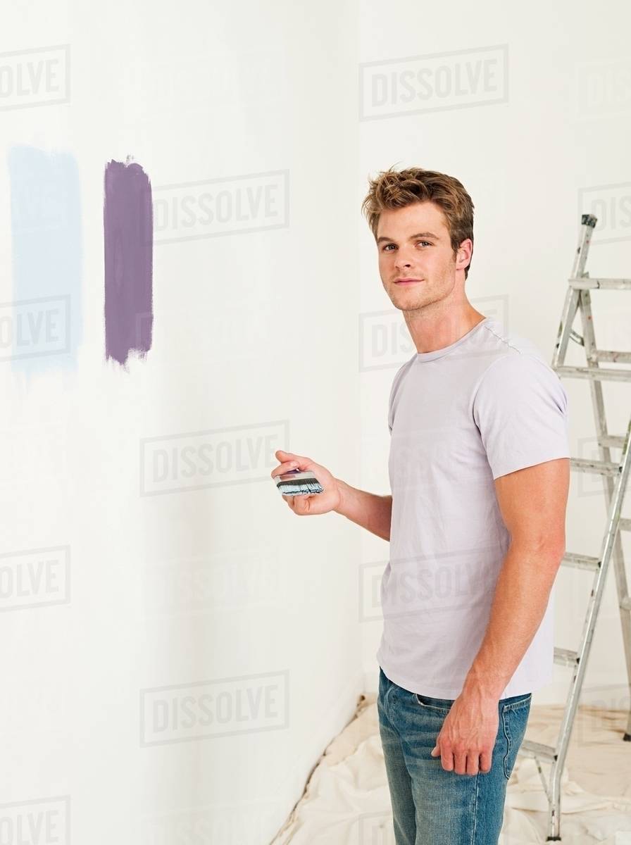 Young man with paint on wall - Stock Photo - Dissolve