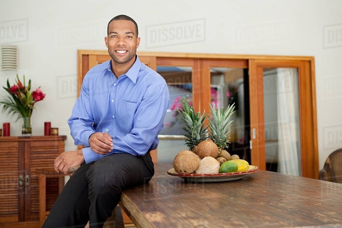 Young man sitting on table - Royalty-free Stock Photo | Dissolve
