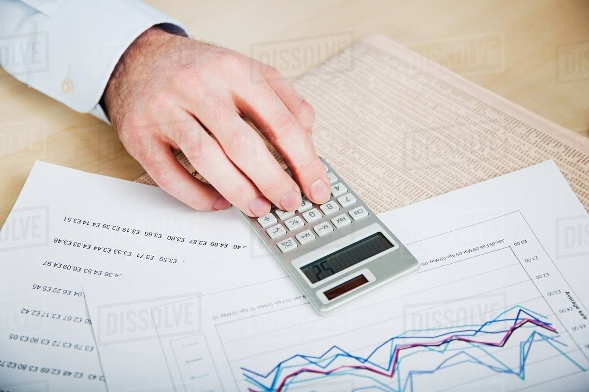 Office worker using calculator - Stock Photo - Dissolve