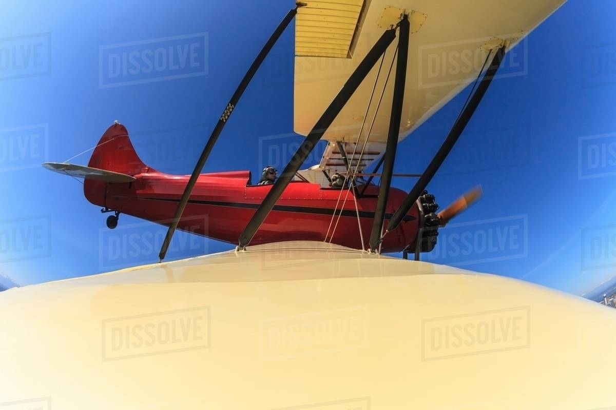 Elevated wide angle view of bi-plane wing and pilot in flight - Royalty ...