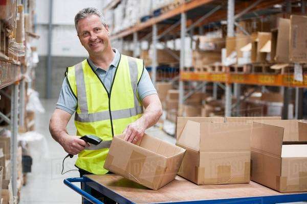 Man using barcode reader in warehouse - Royalty-free Stock Photo | Dissolve