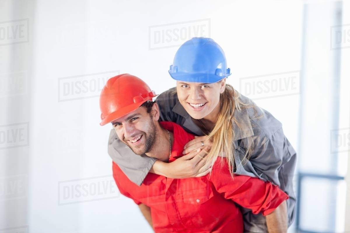 Young couple having fun on construction site - Stock Photo - Dissolve