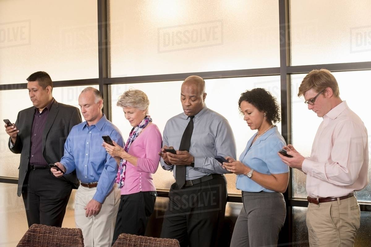 Business colleagues using cell phones - Royalty-free Stock Photo | Dissolve
