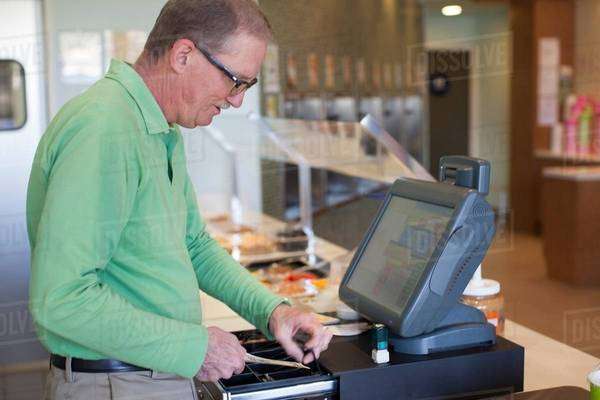 Cashier operating till in store - Royalty-free Stock Photo | Dissolve