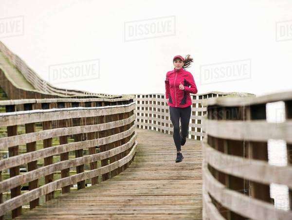Woman running on wooden dock - Royalty-free Stock Photo | Dissolve