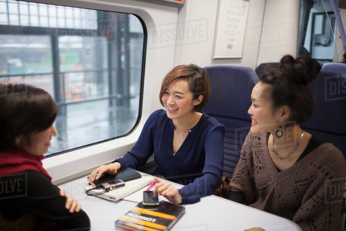 Young women talking on train - Royalty-free Stock Photo | Dissolve
