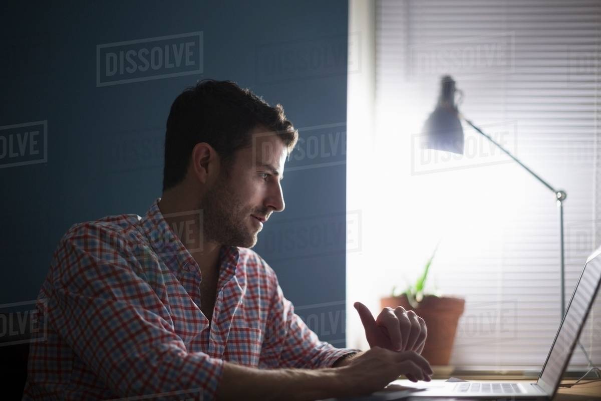 Man sitting at desk typing - Stock Photo - Dissolve