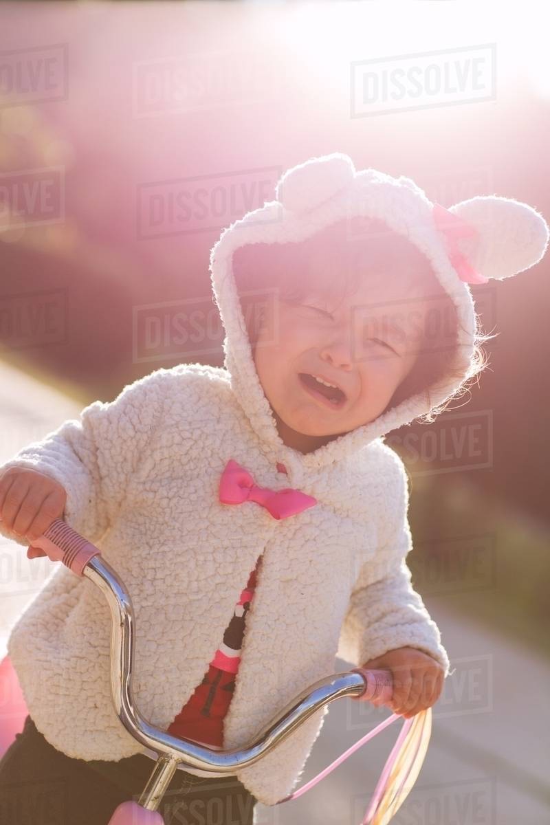 Little girl learning to ride tricycle - Royalty-free Stock Photo | Dissolve