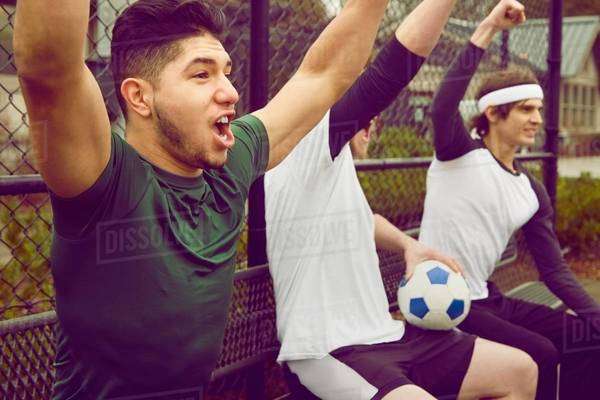 Three male soccer player spectators celebrating - Stock Photo - Dissolve