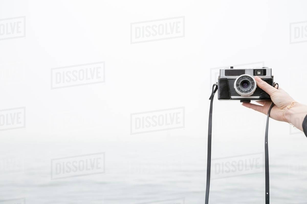 Person taking selfie with camera, sea in background - Stock Photo ...
