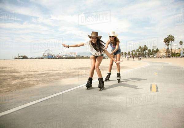 Portrait of two young women, inline skating - Stock Photo - Dissolve