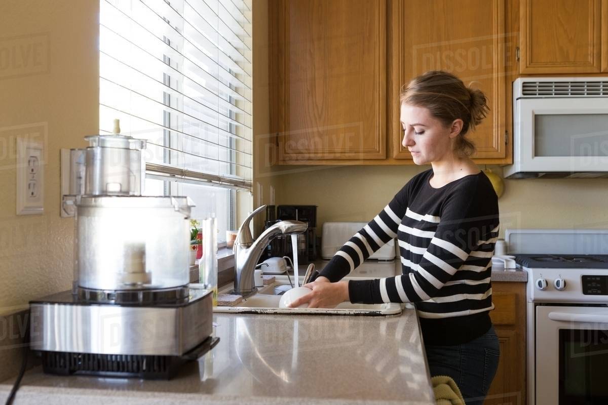 Woman washing up in kitchen - Royalty-free Stock Photo | Dissolve