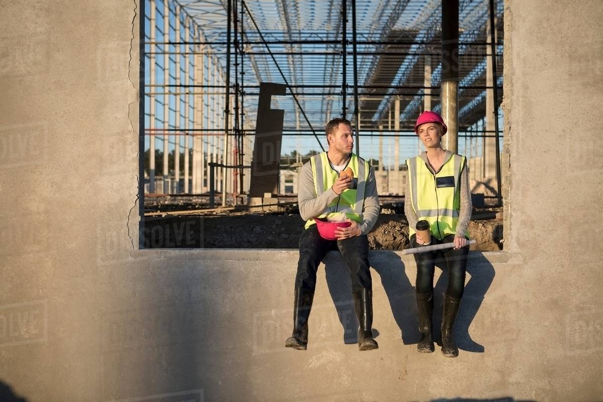 Builder and architect taking a break on construction site - Royalty ...
