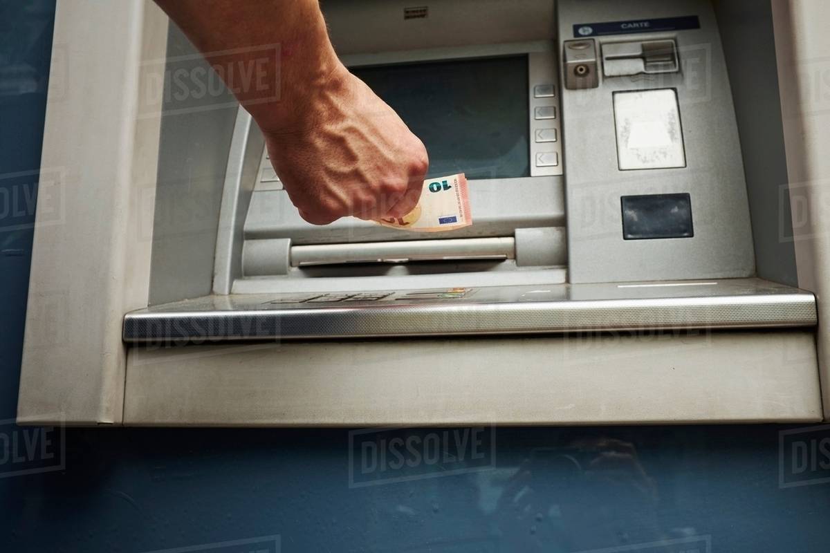 Mid adult man using cash machine, focus on hands - Royalty-free Stock ...