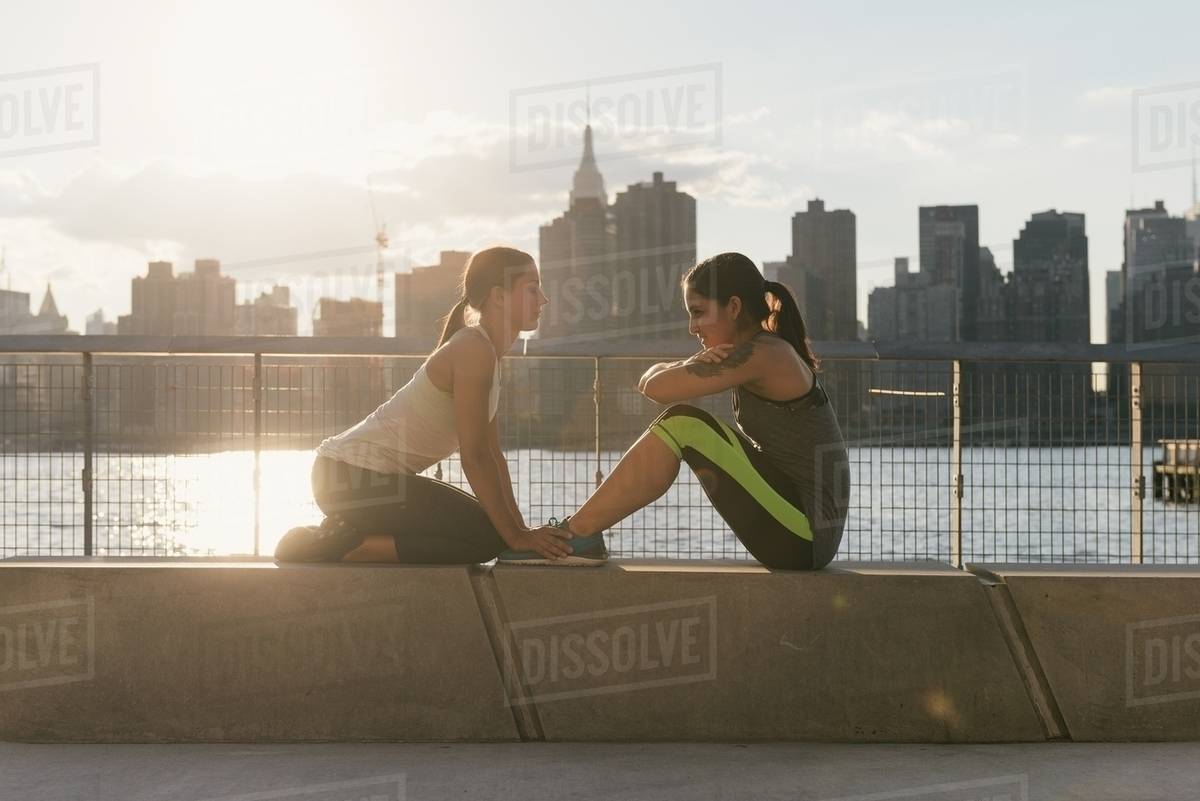 Two friends exercising together and helping to do sit ups - Stock Photo ...