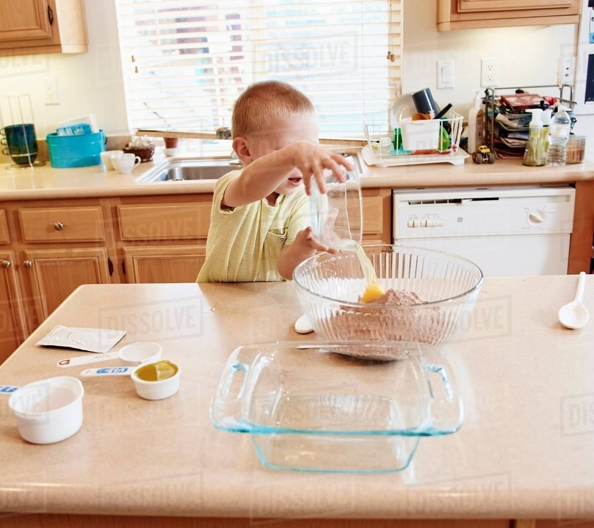 Boy preparing batter in mixing bowl - Royalty-free Stock Photo | Dissolve