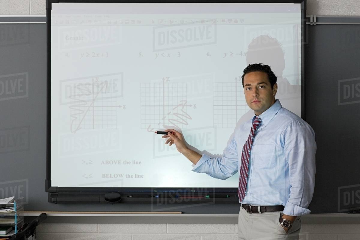 A teacher pointing at a projector screen - Stock Photo - Dissolve