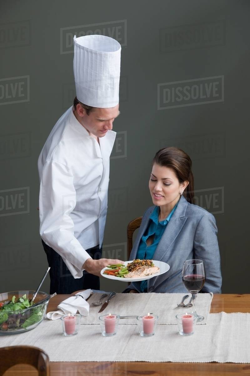A chef serving a woman with a meal - Royalty-free Stock Photo | Dissolve