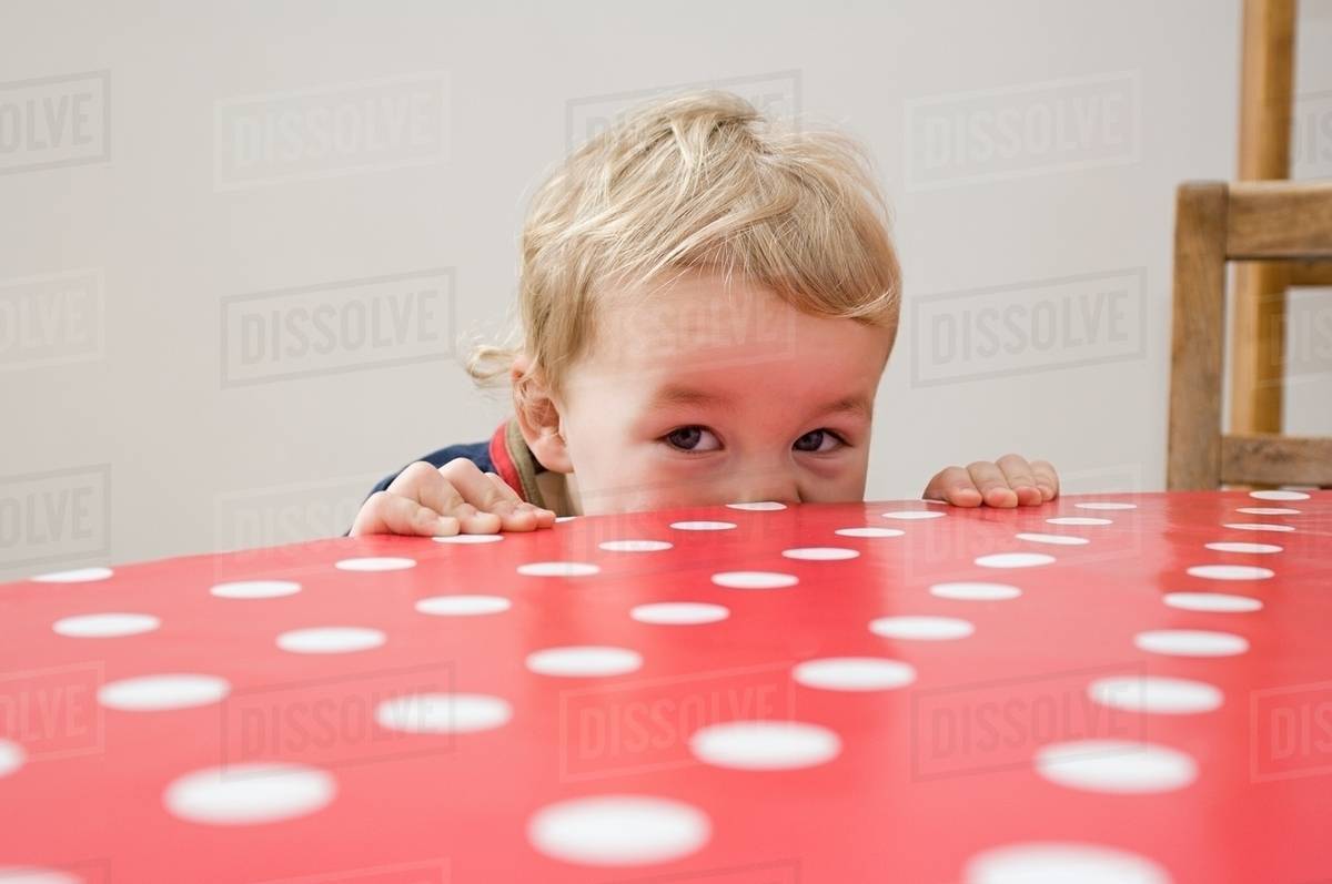Boy looking over table - Royalty-free Stock Photo | Dissolve