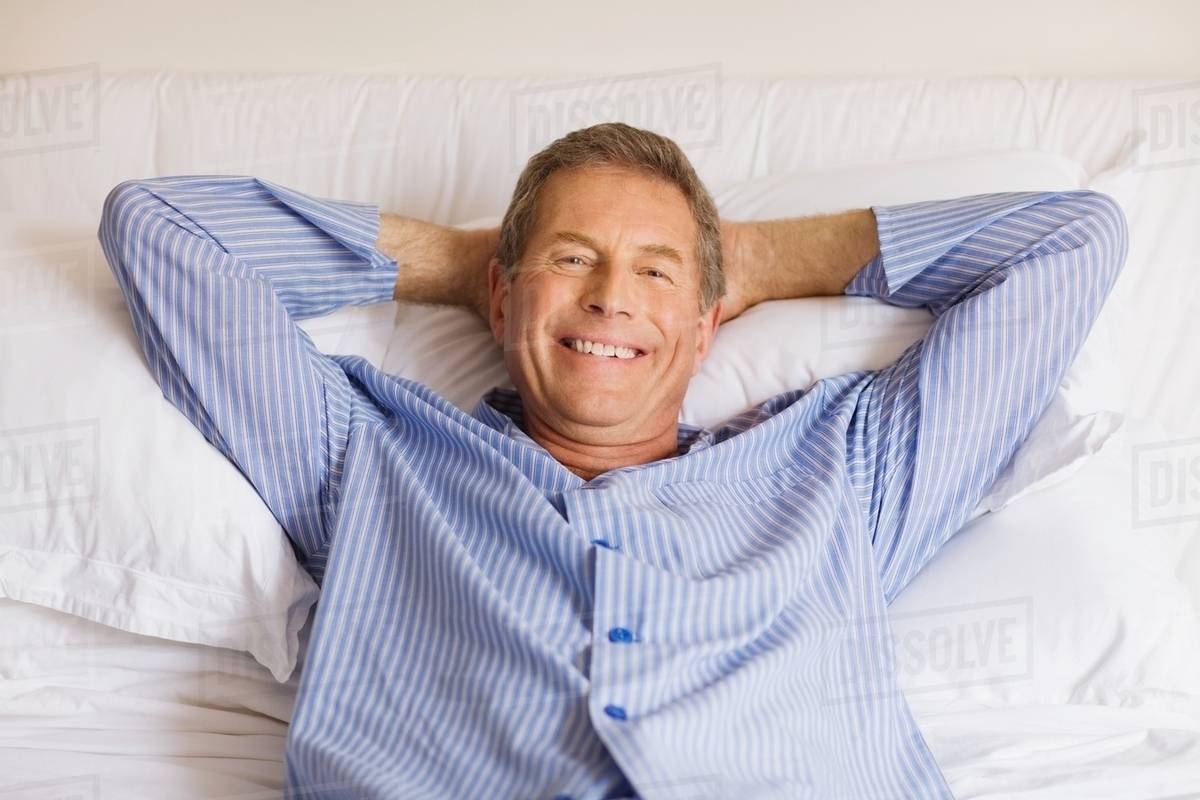 Portrait of a senior man lying in bed - Royalty-free Stock Photo | Dissolve