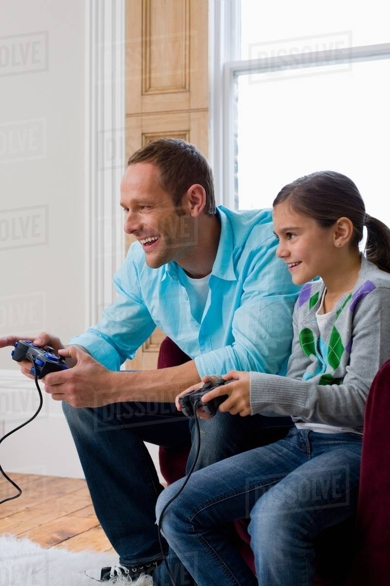 Father and daughter playing video game - Royalty-free Stock Photo ...