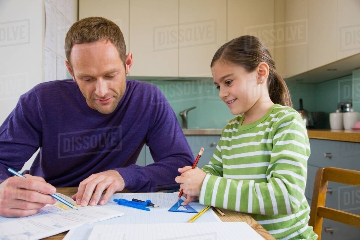 Father helping his daughter with homework - Stock Photo - Dissolve