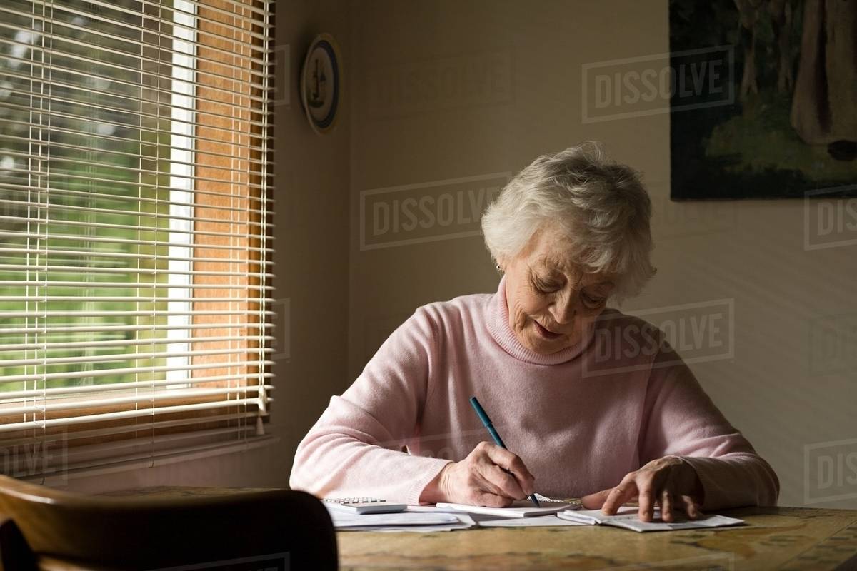 Senior woman writing - Royalty-free Stock Photo | Dissolve