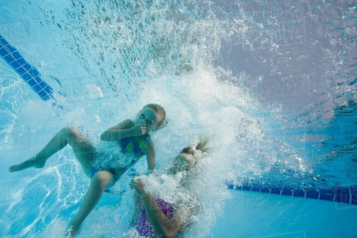 Girls jumping in swimming pool - Royalty-free Stock Photo | Dissolve