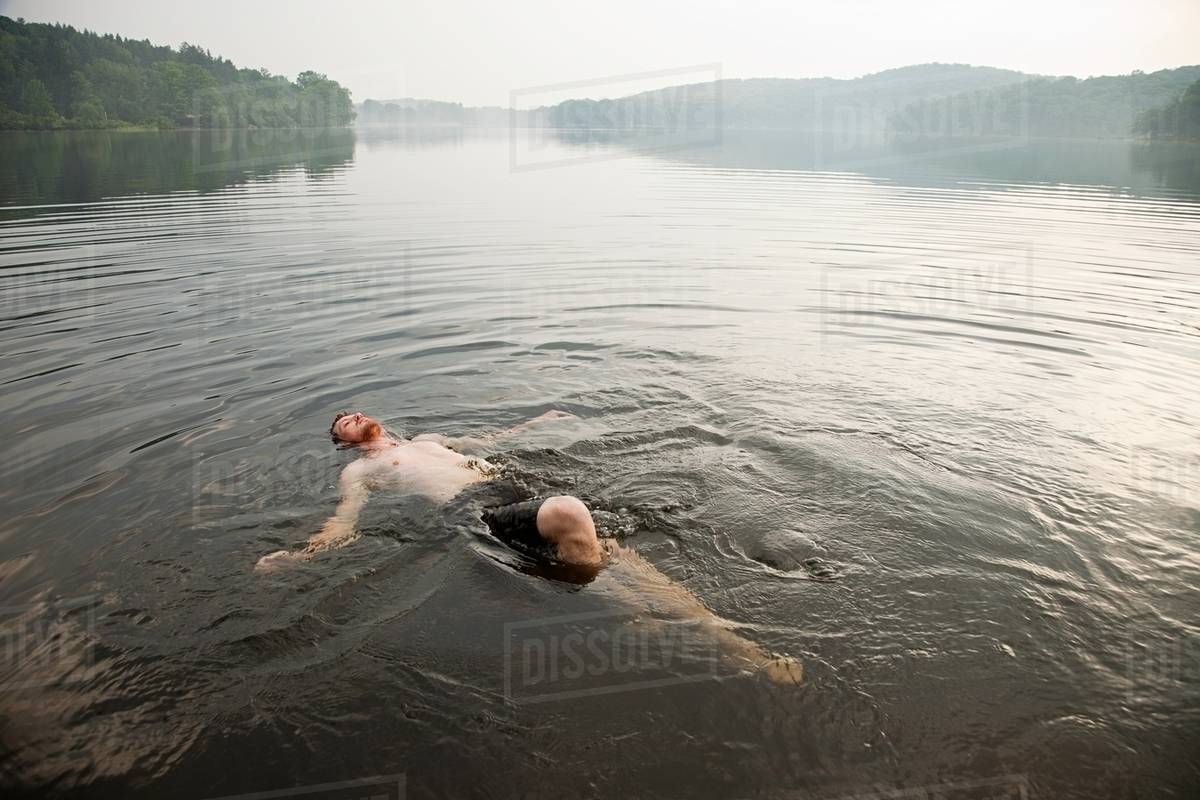 Mid adult man swimming in lake - Royalty-free Stock Photo | Dissolve
