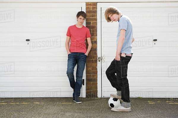 Teenage boys by garages - Stock Photo - Dissolve