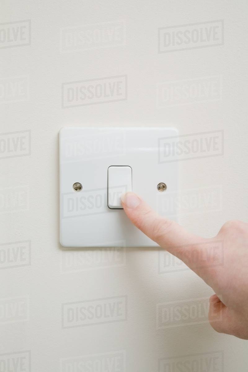 Person using light switch - Stock Photo - Dissolve