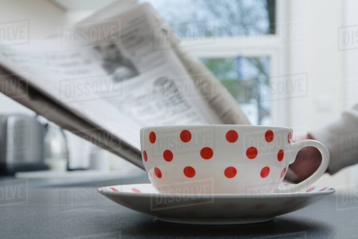 Person with tea and newspaper - Royalty-free Stock Photo | Dissolve