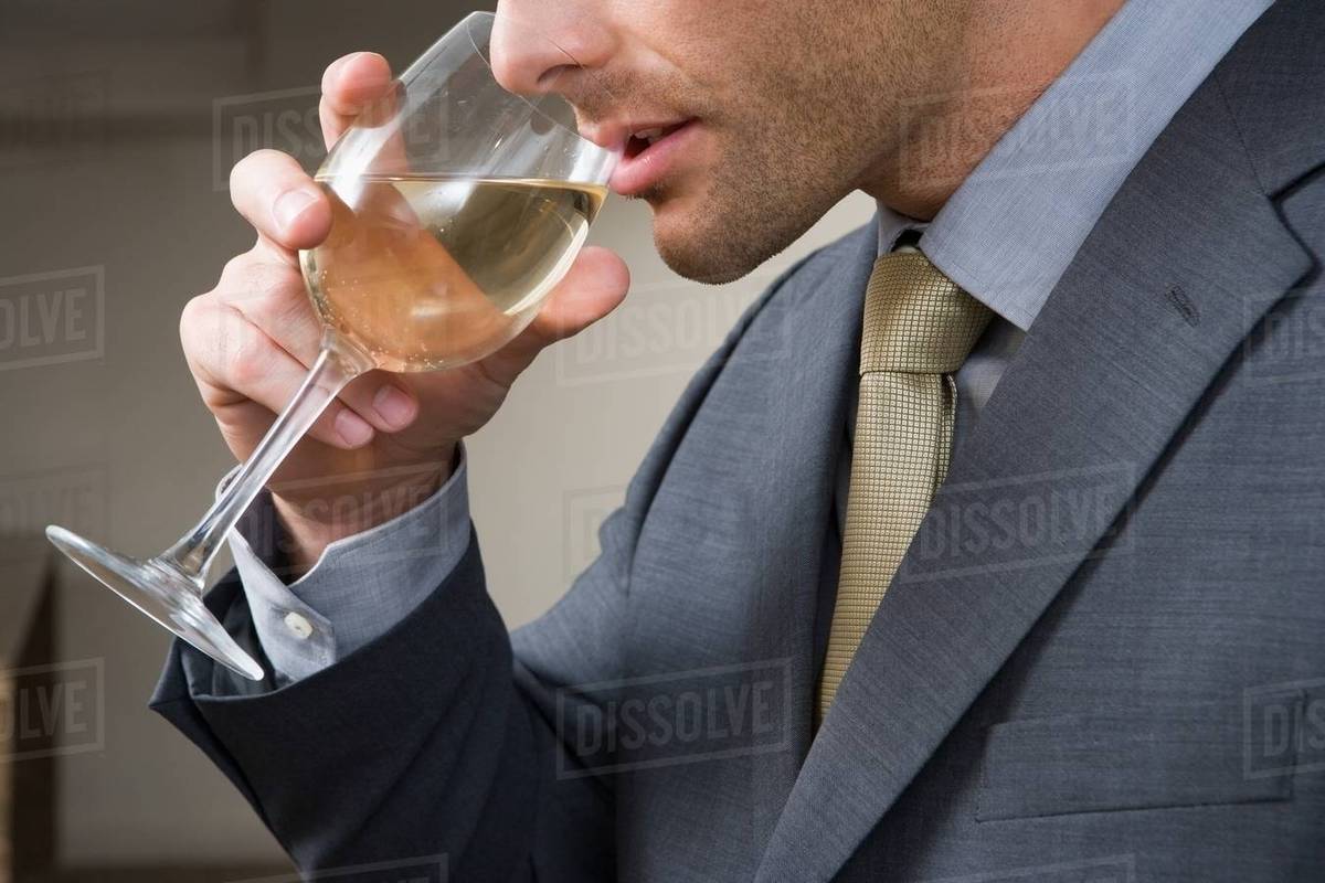 Businessman drinking white wine - Royalty-free Stock Photo | Dissolve