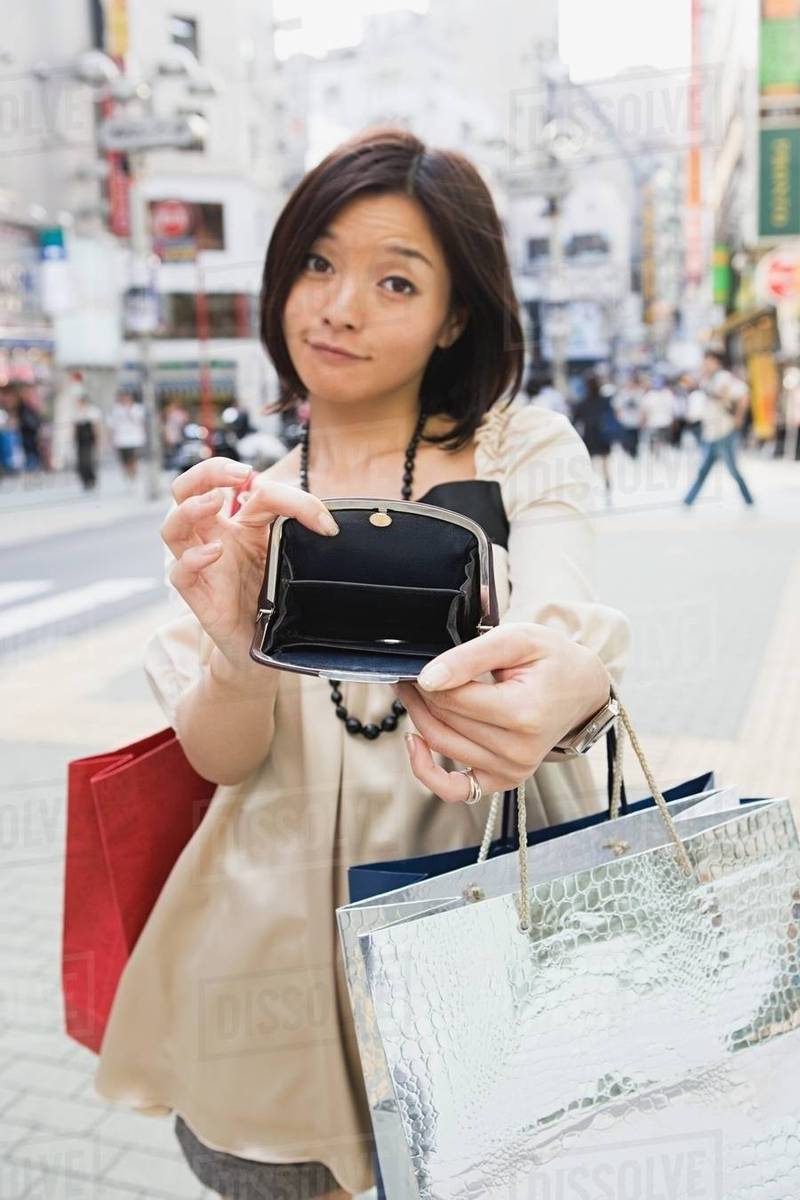 A woman showing her empty purse - Stock Photo - Dissolve