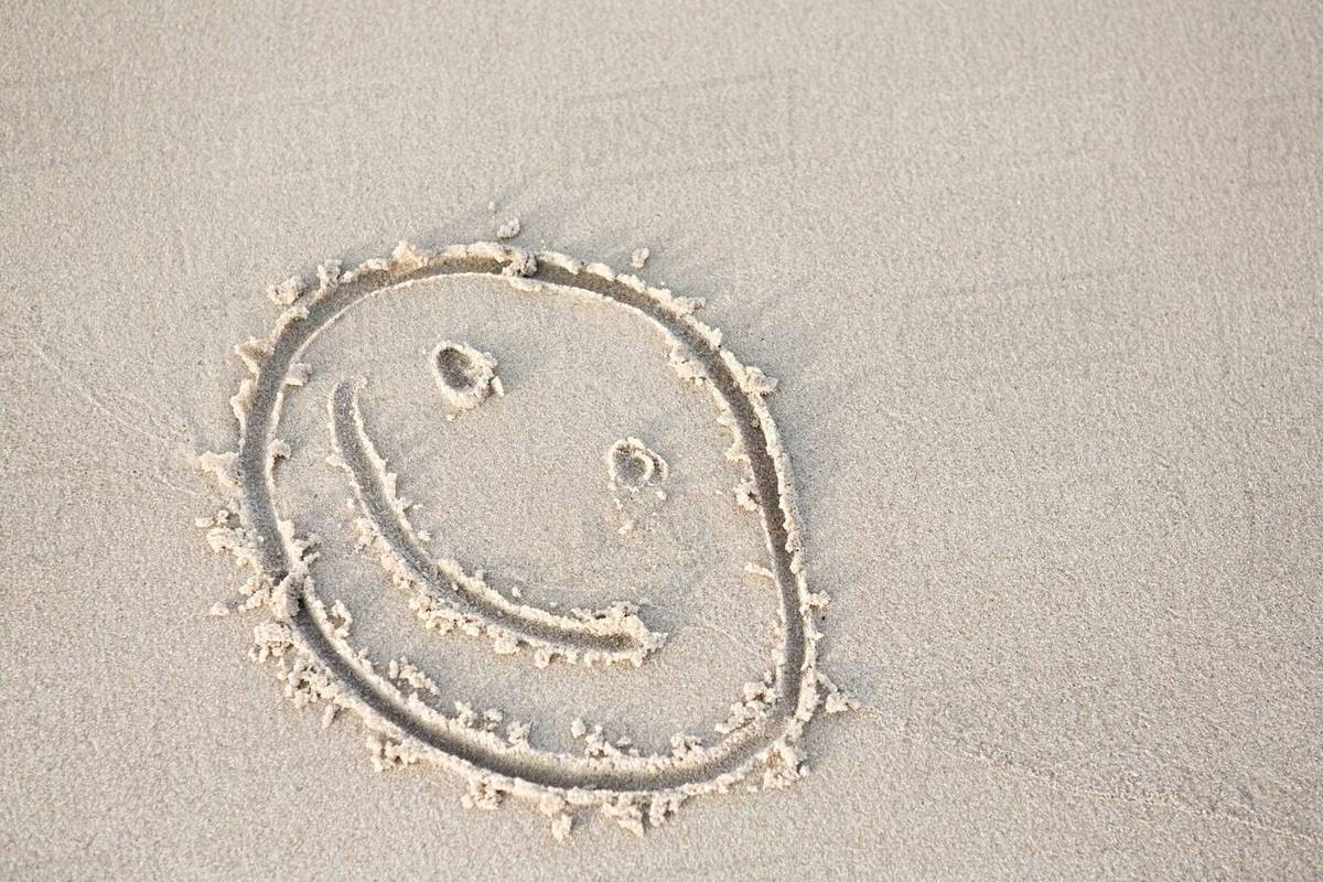 Smiley face in the sand - Stock Photo - Dissolve