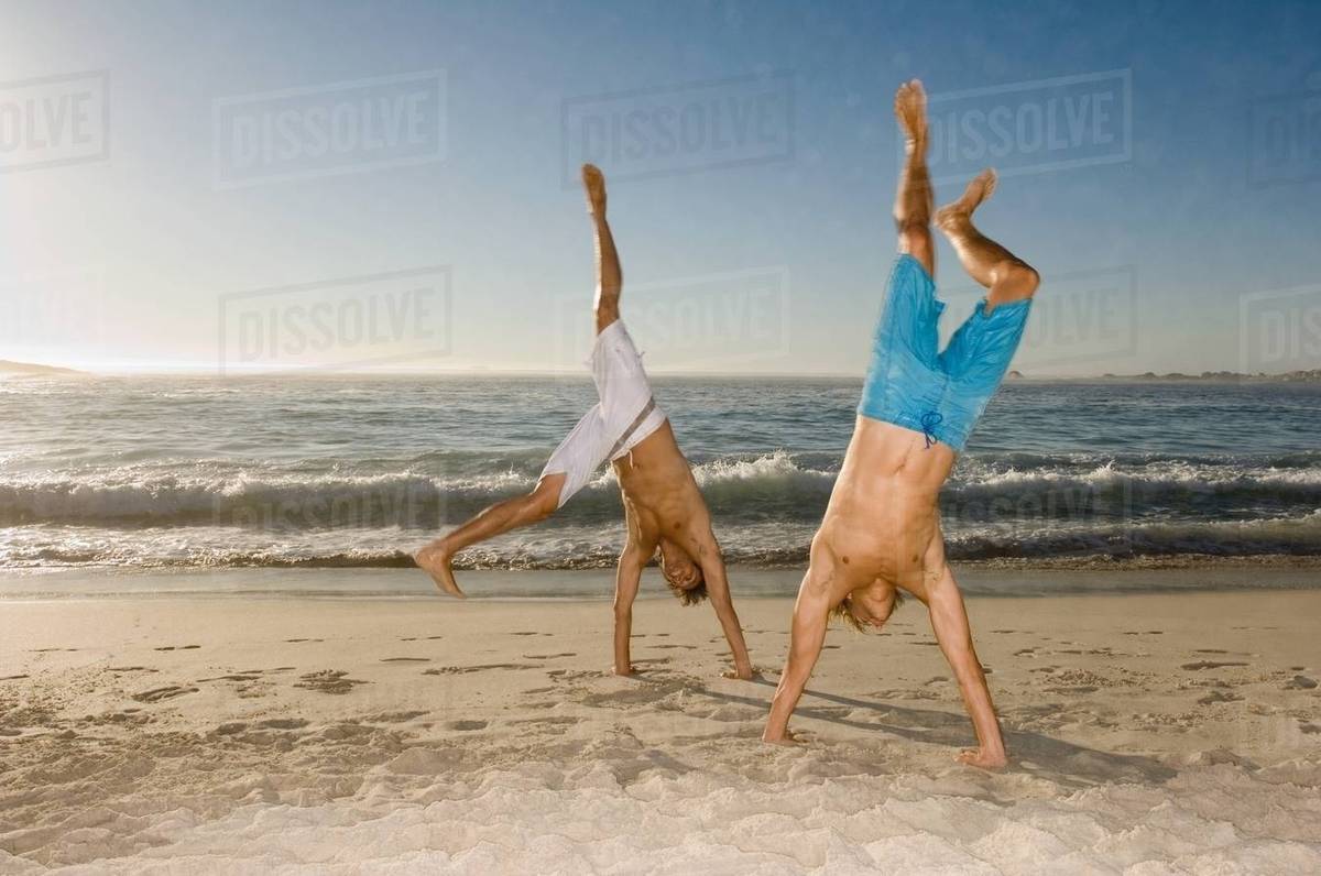 Young men doing cartwheels - Stock Photo - Dissolve