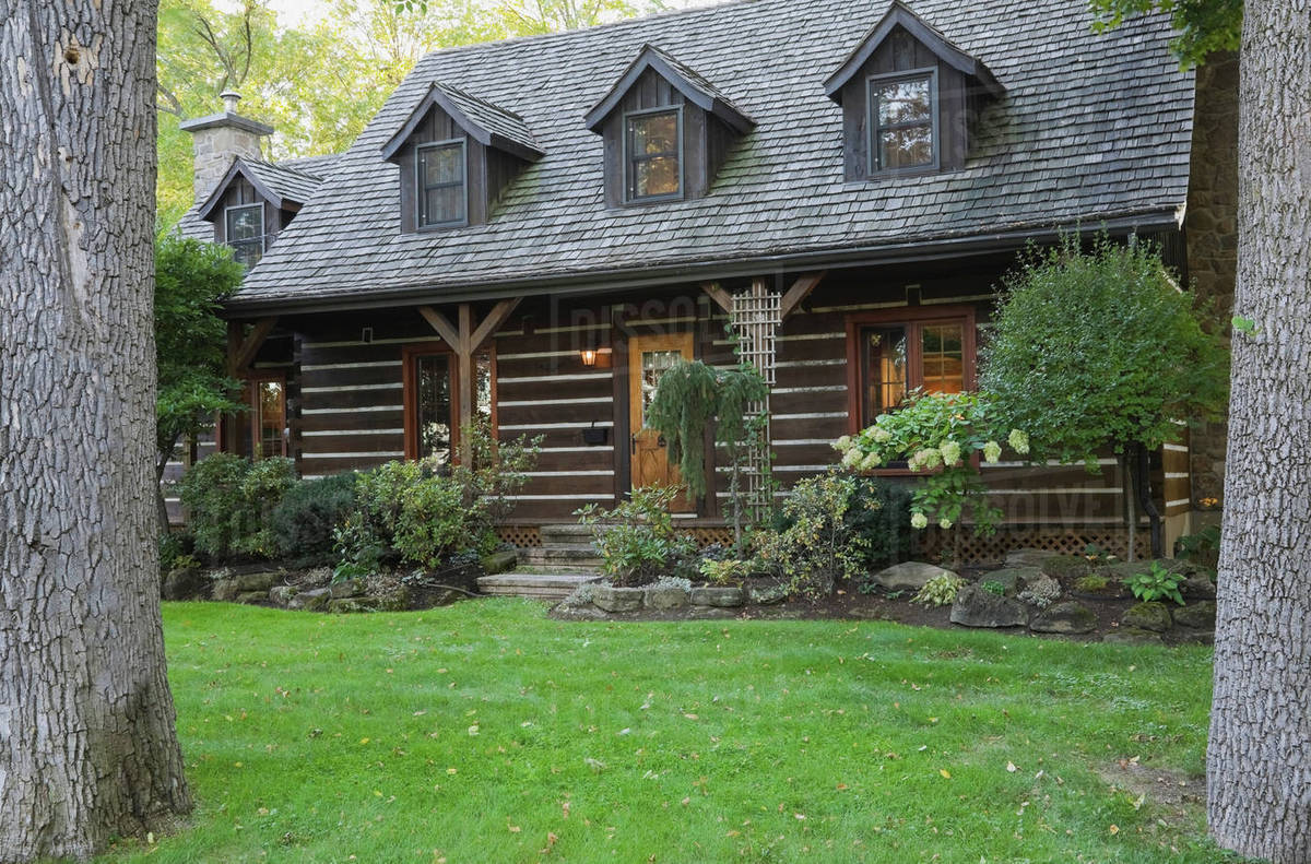 Exterior of Canadian cottage style home with cedar shingles and garden ...