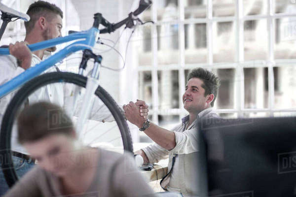 Colleagues greeting with power handshake in office - Royalty-free Stock ...