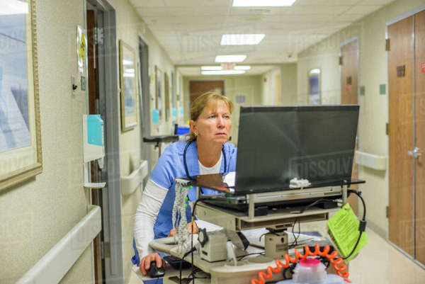 Hospital staff using computer for analysing and monitoring patient ...
