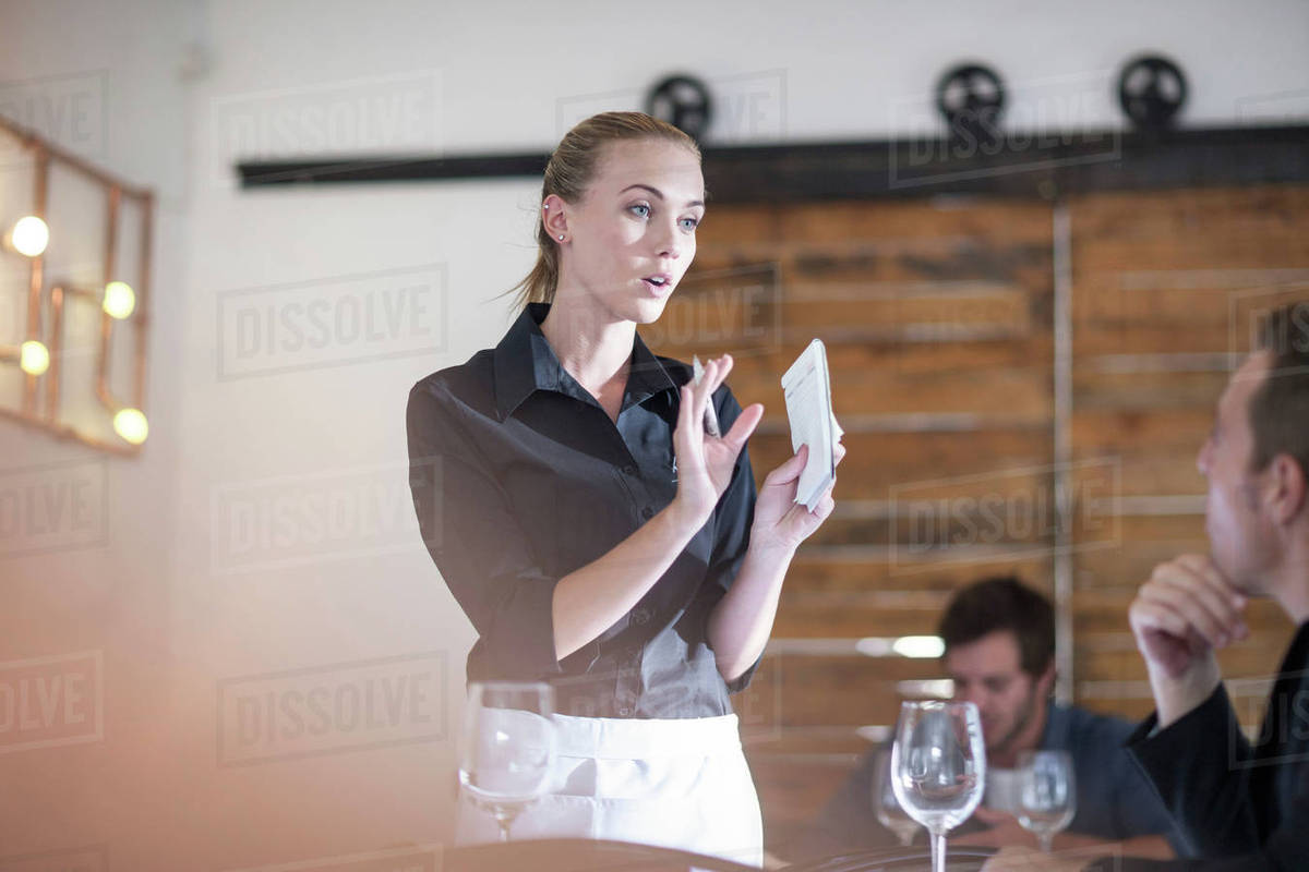 Waitress explaining to customer in restaurant - Royalty-free Stock ...