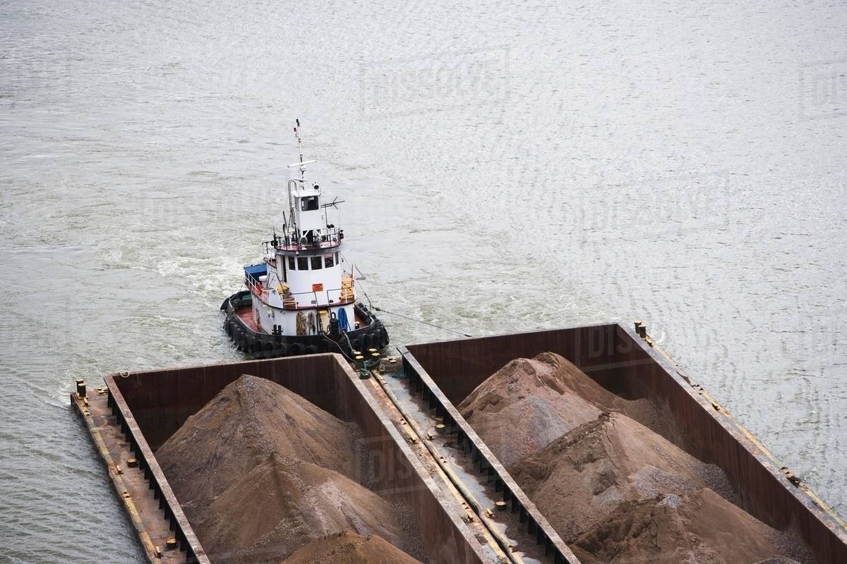 Tugboat pushing barges of sand, high angle view - Royalty-free Stock ...