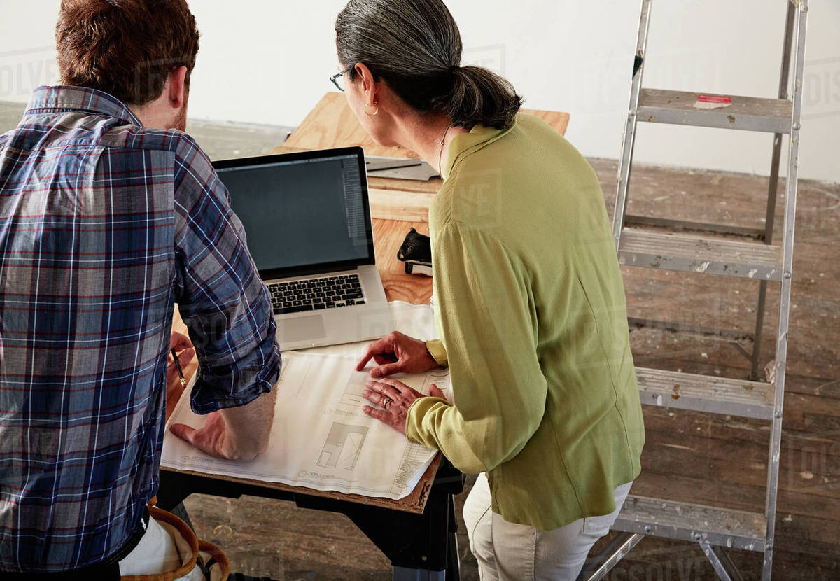 Carpenter and client with blueprints using laptop - Royalty-free Stock ...