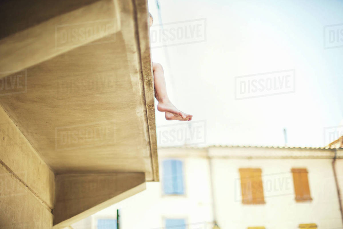 Person sitting on wooden ledge, low angle view, Boutenac, France ...