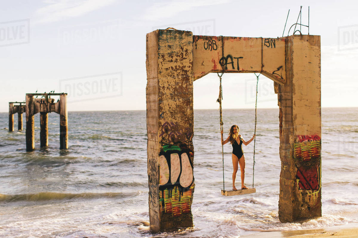 Woman standing on swing, Old Davenport Pier, Santa Cruz, California ...
