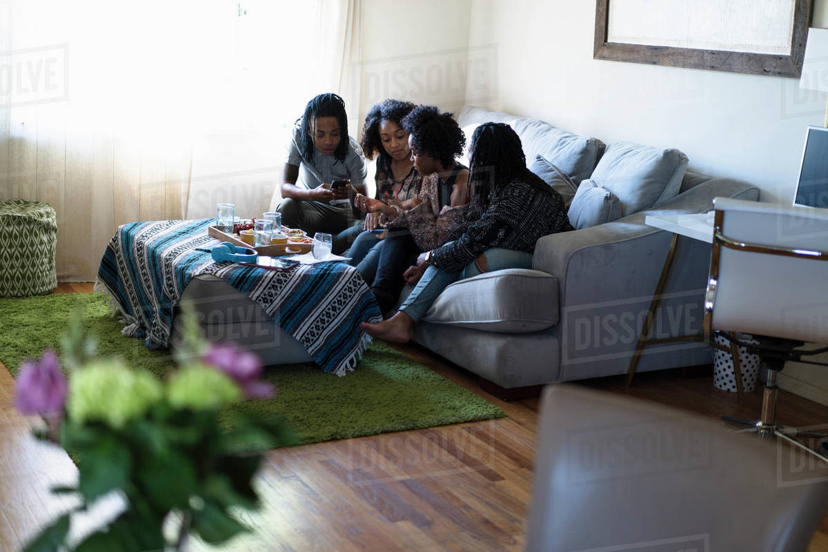 Four female friends relaxing at home - Royalty-free Stock Photo | Dissolve